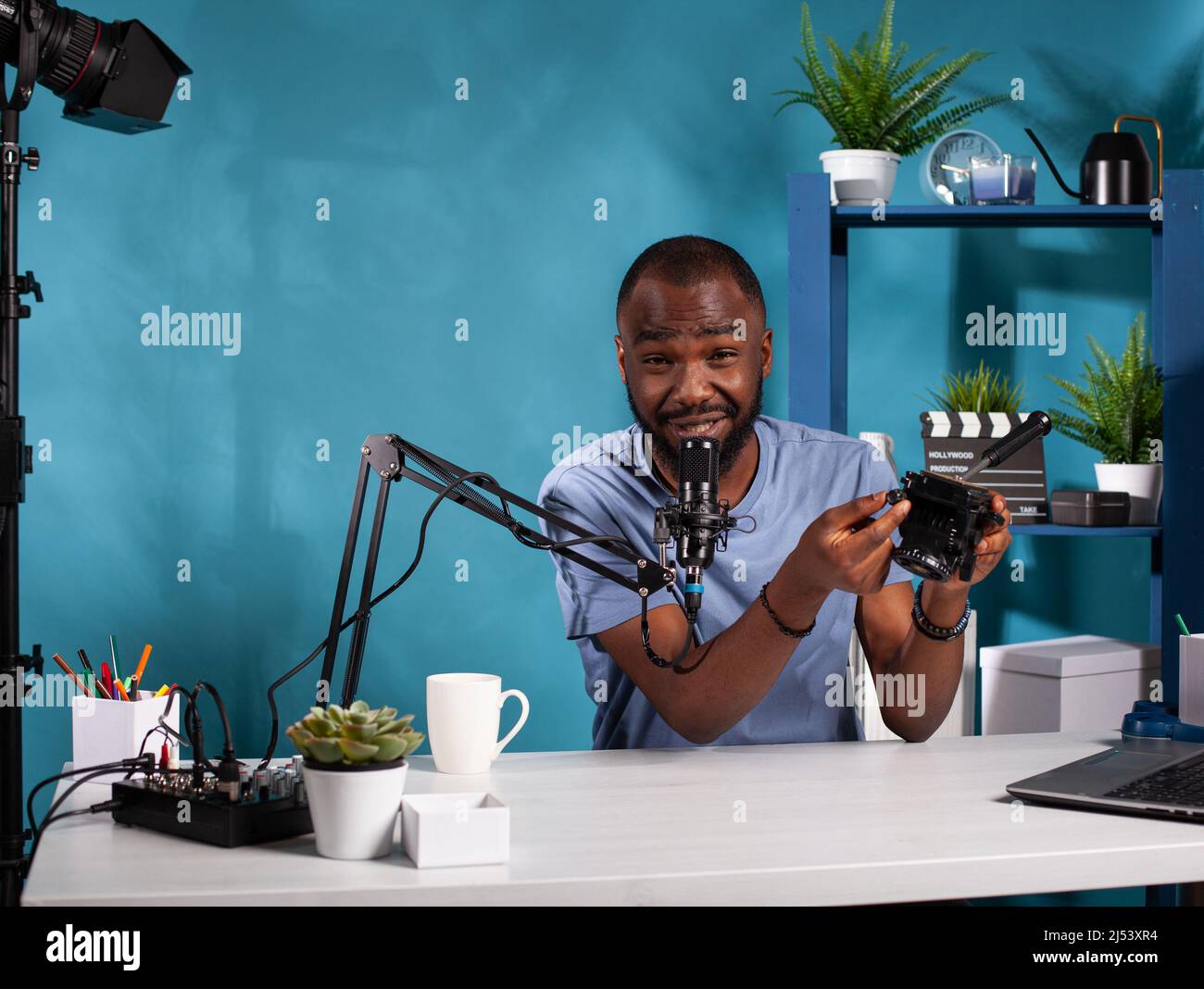 Portrait of videographer reviewer presenting fluid tripod head for ...