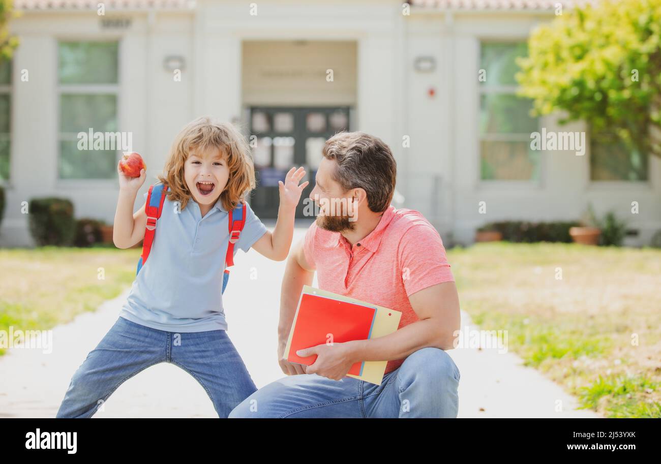 Teachers day. Father and son walking trough school park. Parent taking ...