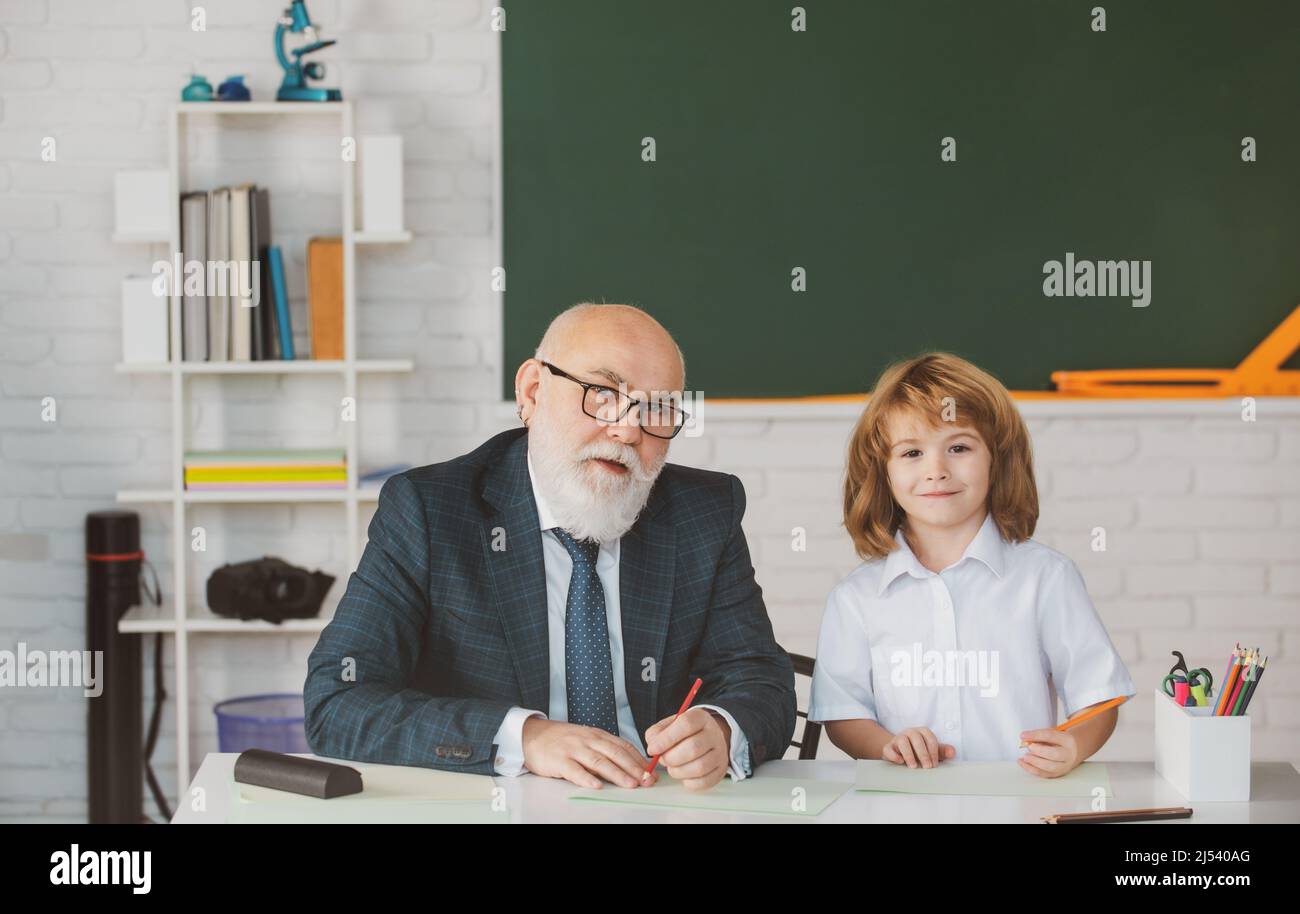 Education and learning. Teacher and pupil in school. Schoolboy in ...