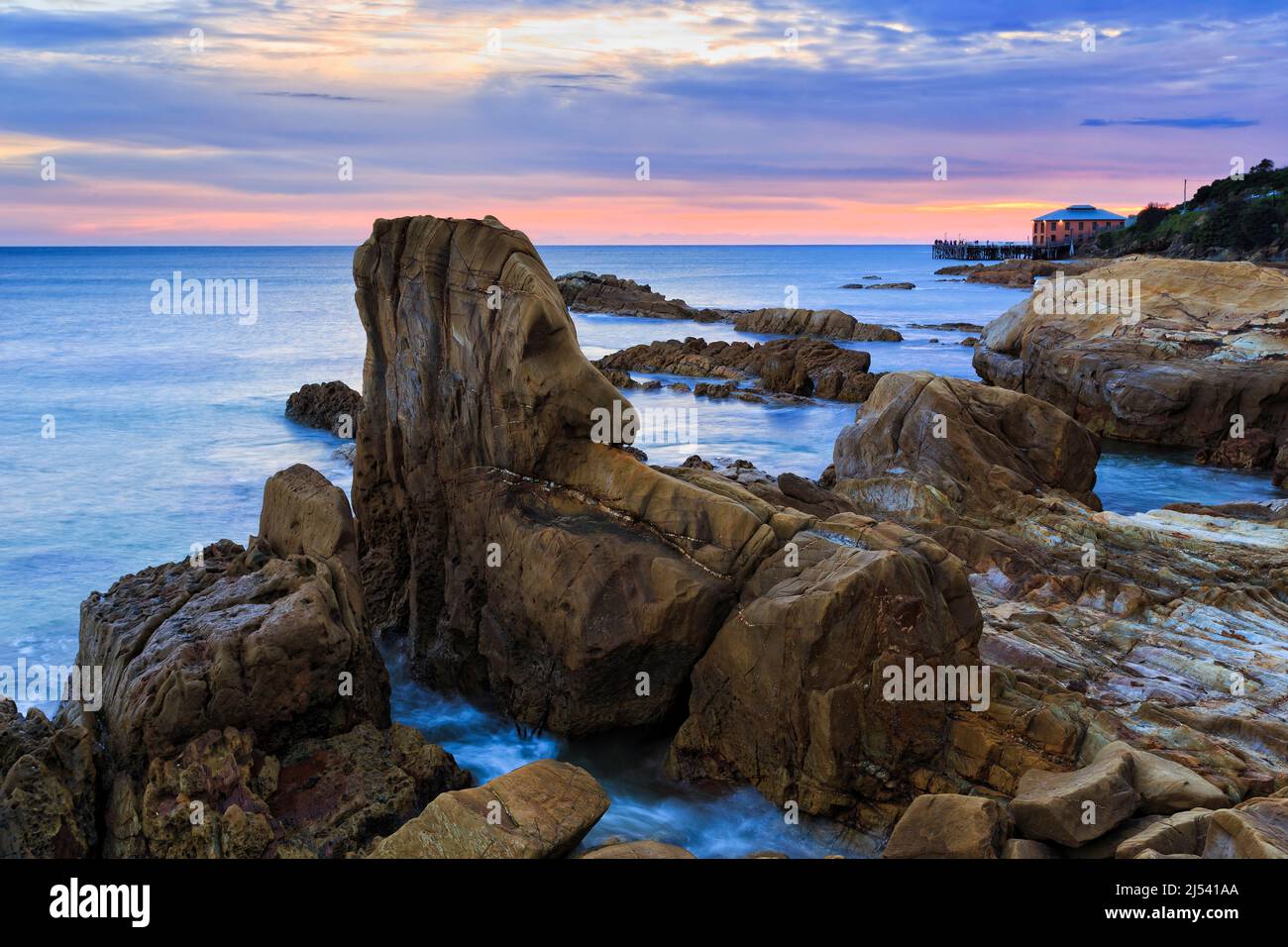 Sandstone rocks and cliffs at Tathra beach and headland towards ...
