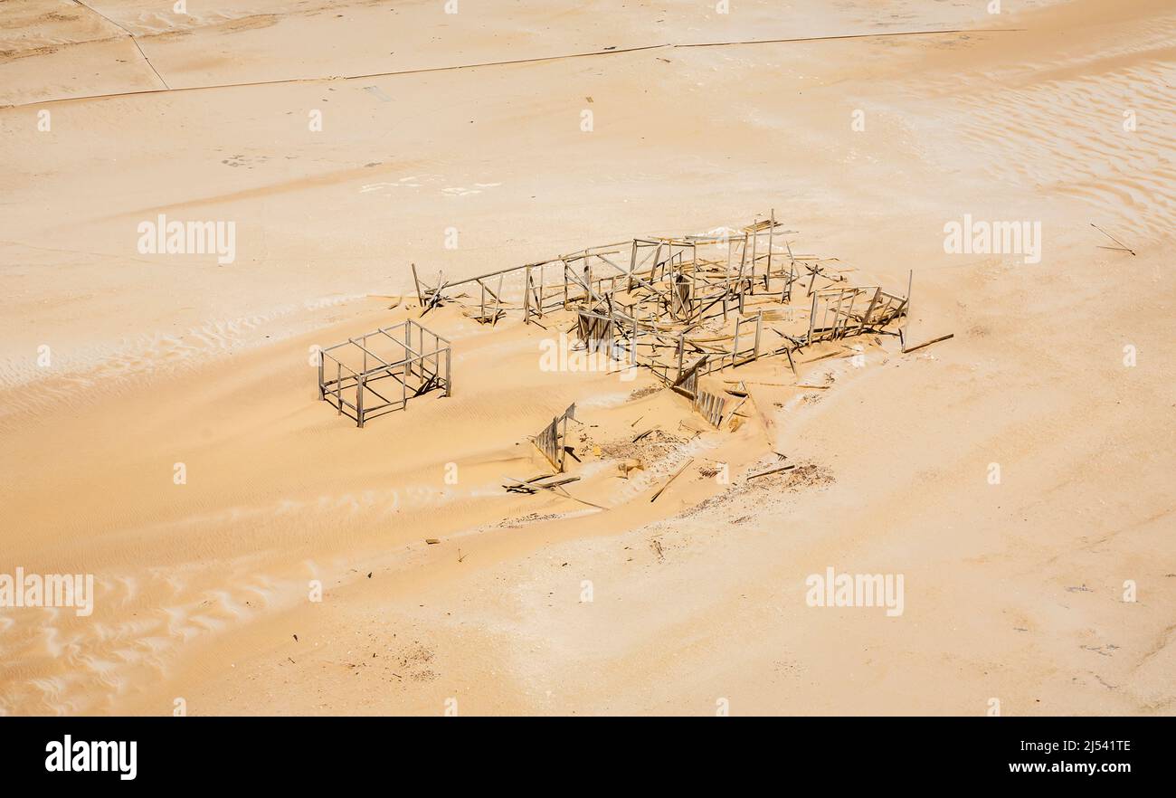 The wooden skeleton structure of a long abandoned building in the sand ...