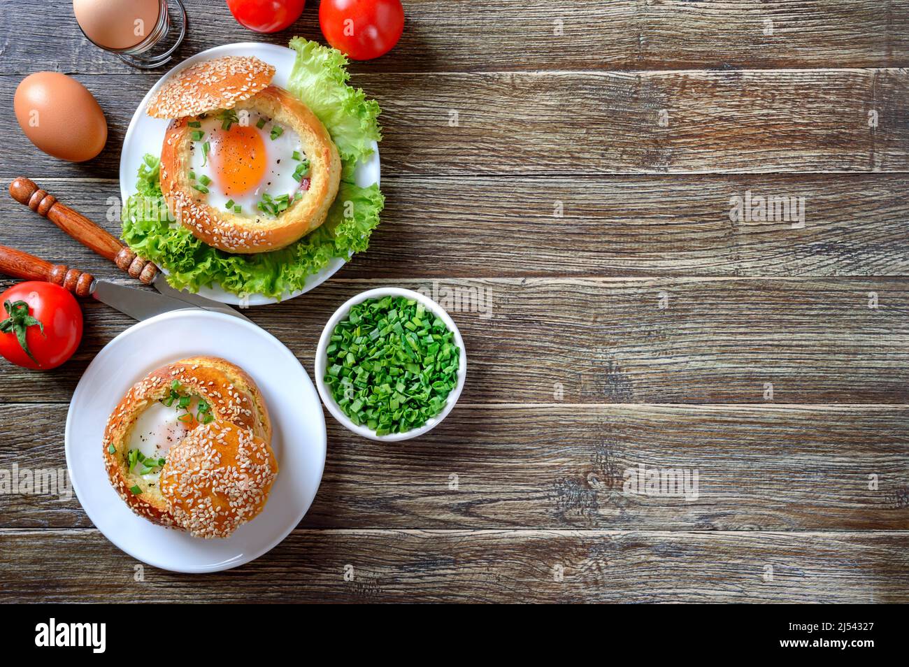 Food background with copy space. Eggs baked in a bun with ham, cheese ...