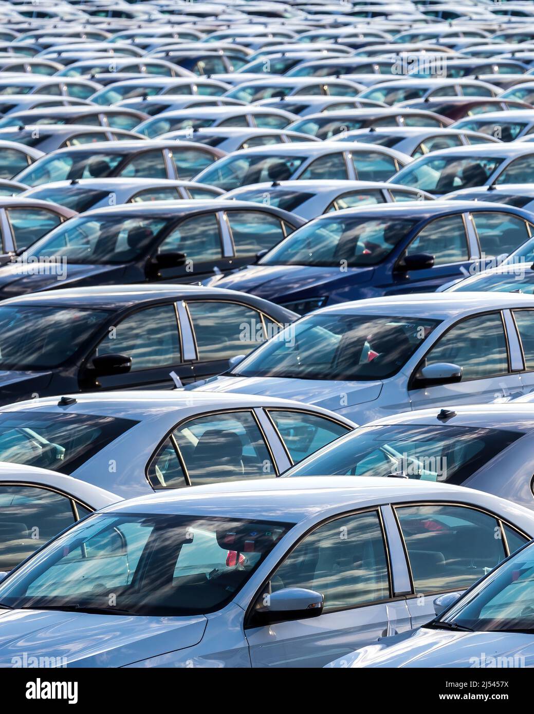 Rows of a new cars parked in a distribution center on a car factory ...