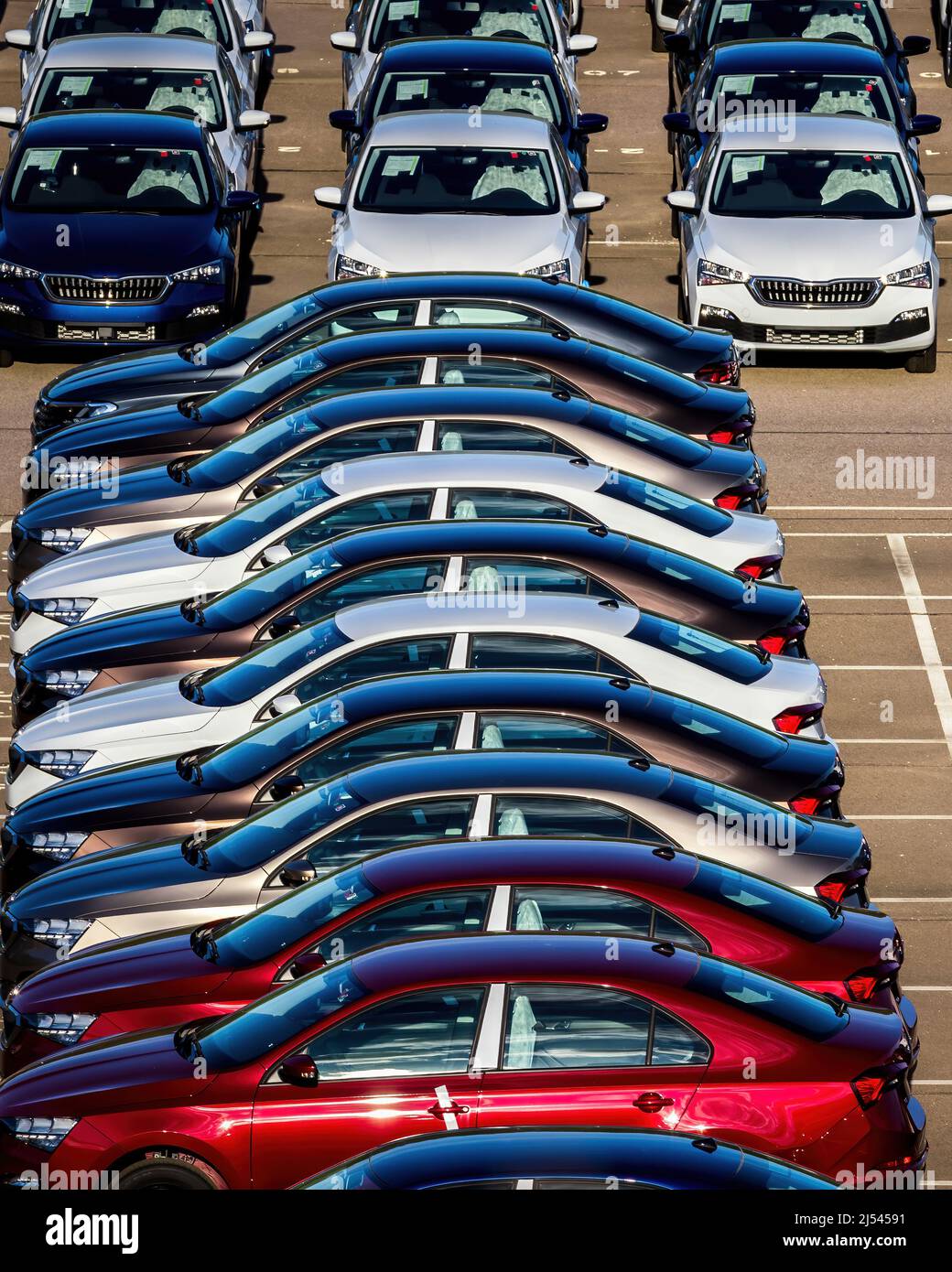 Rows of a new cars parked in a distribution center on a car factory ...