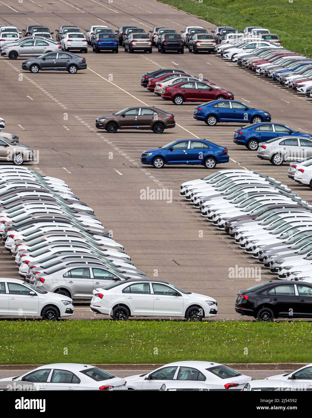 Rows of a new cars parked in a distribution center on a car factory ...