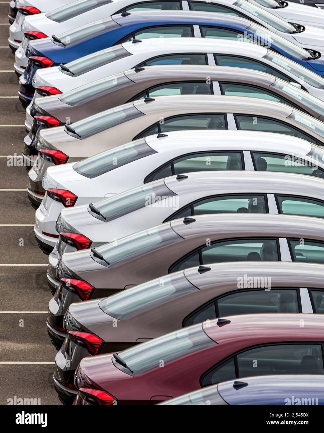 Rows of a new cars parked in a distribution center on a car factory ...