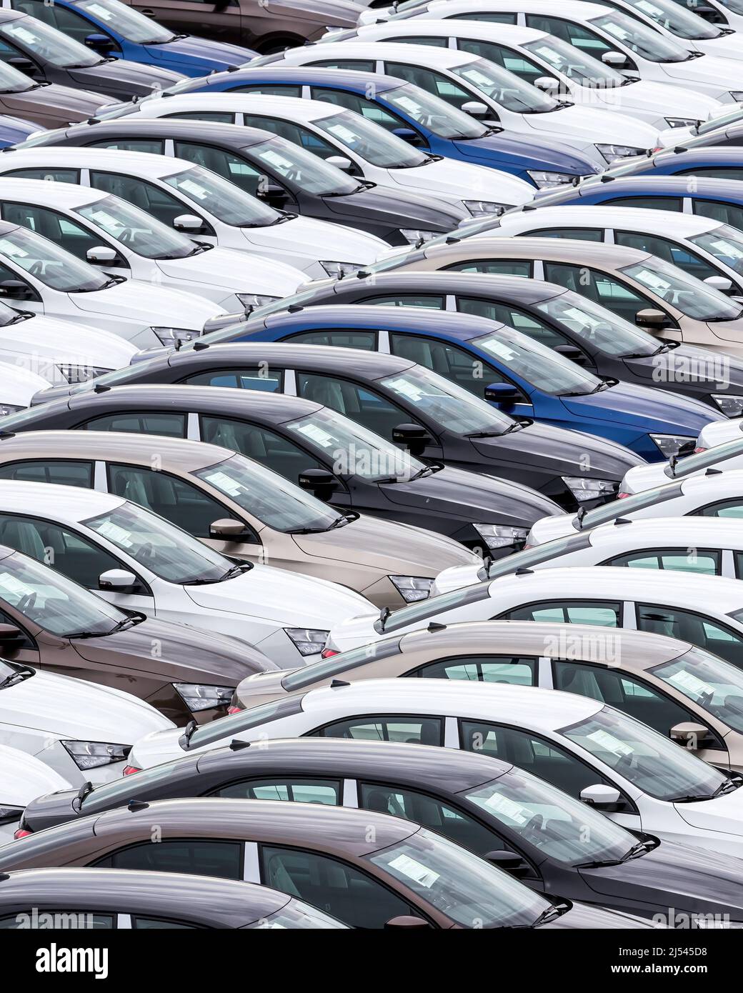 Rows of a new cars parked in a distribution center on a car factory ...