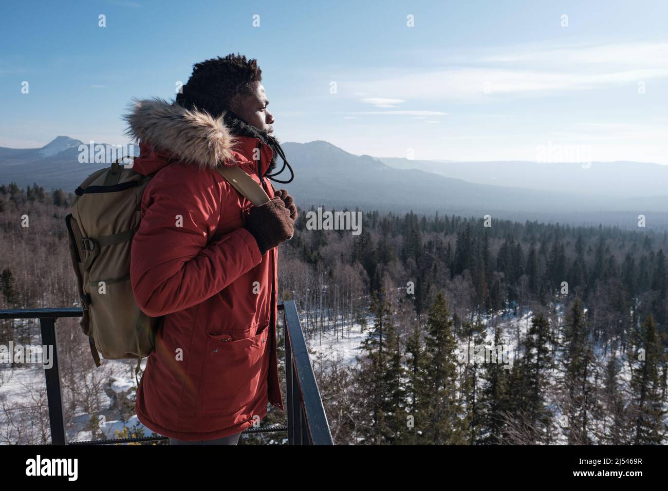 Young African American guy wearing backpack standing at observation ...