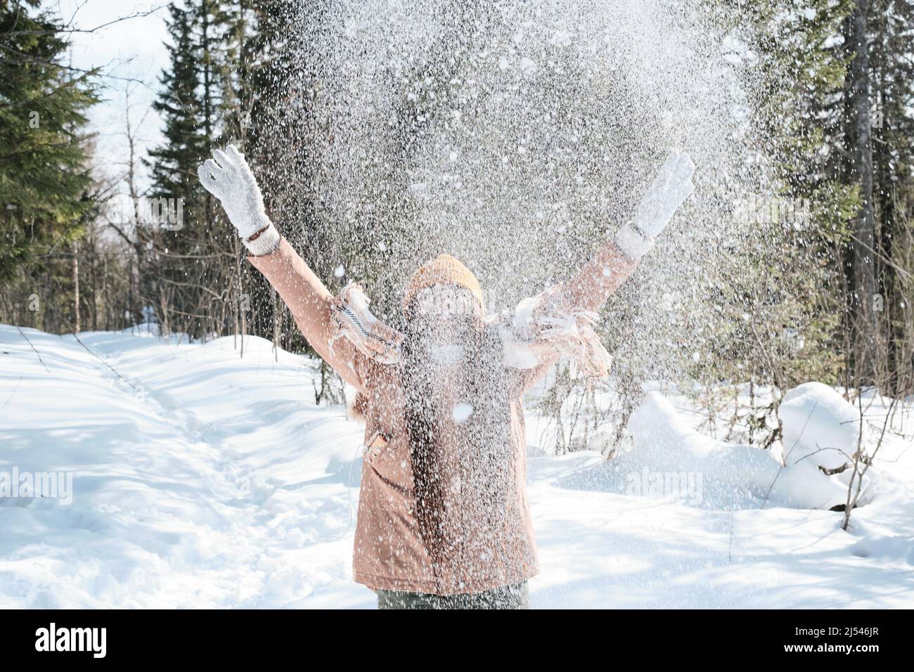 Cheerful young Black woman with long hair spending sunny winter day in ...
