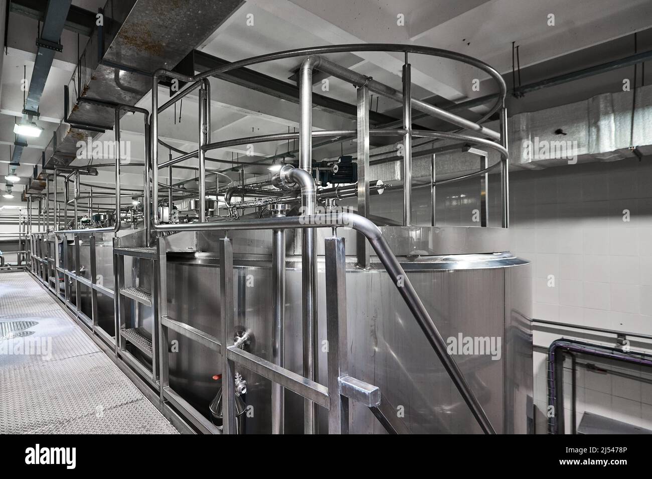 Metal ground near large cisterns for fermented milk products Stock ...