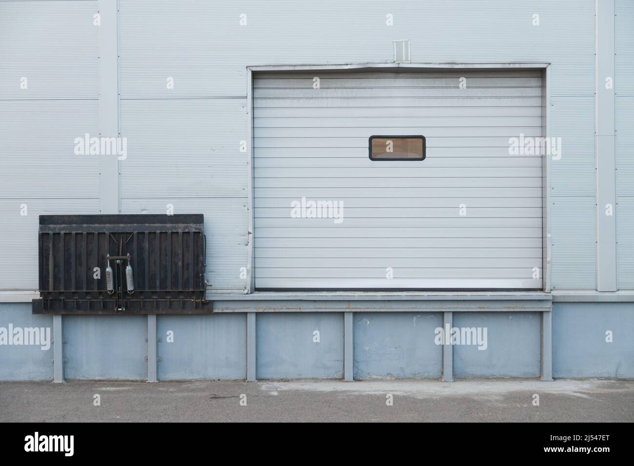 Facade of modern warehouse with gate and lift Stock Photo - Alamy
