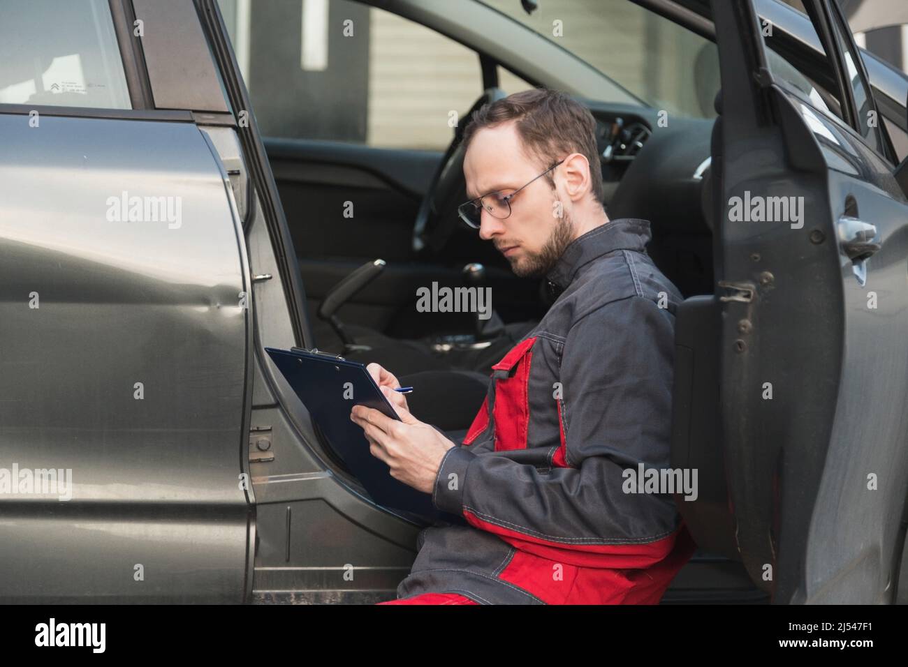 the mechanic checks the door and checks the VIN code of the car, makes ...