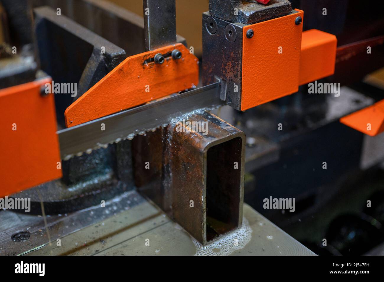 The process of cutting a metal profile on band saw machine Stock Photo ...