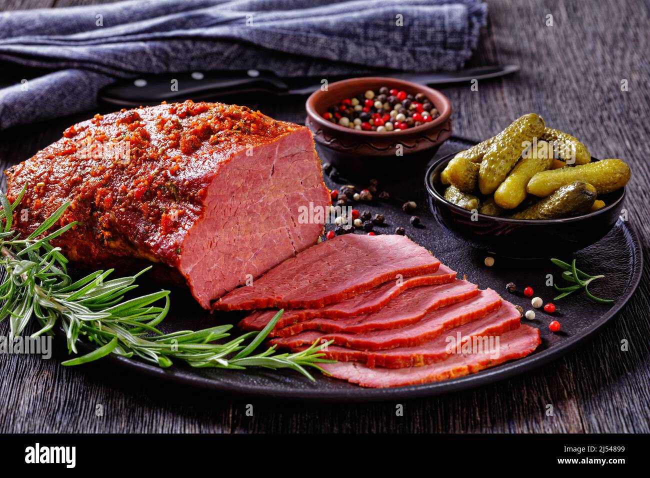 close-up of roast beef pastrami sliced on wooden board with fresh ...