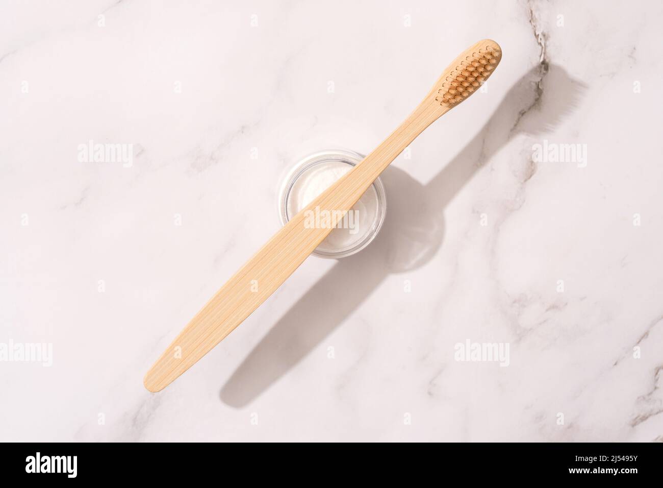 Bamboo toothbrush and mineral toothpowder on white marble table ...