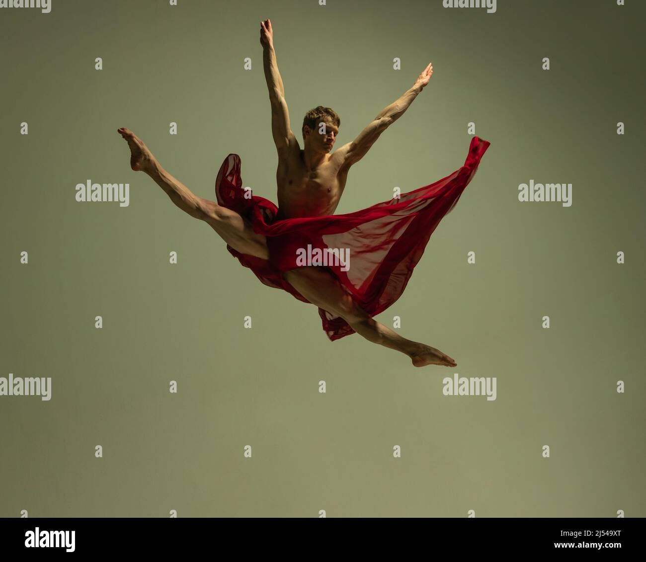 Flight. One young muscled man, flexible ballet dancer in action with ...