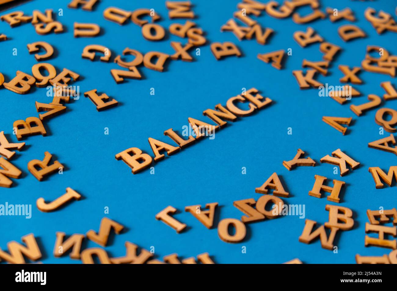 Word BALANCE made out of wooden letters on bright blue background ...