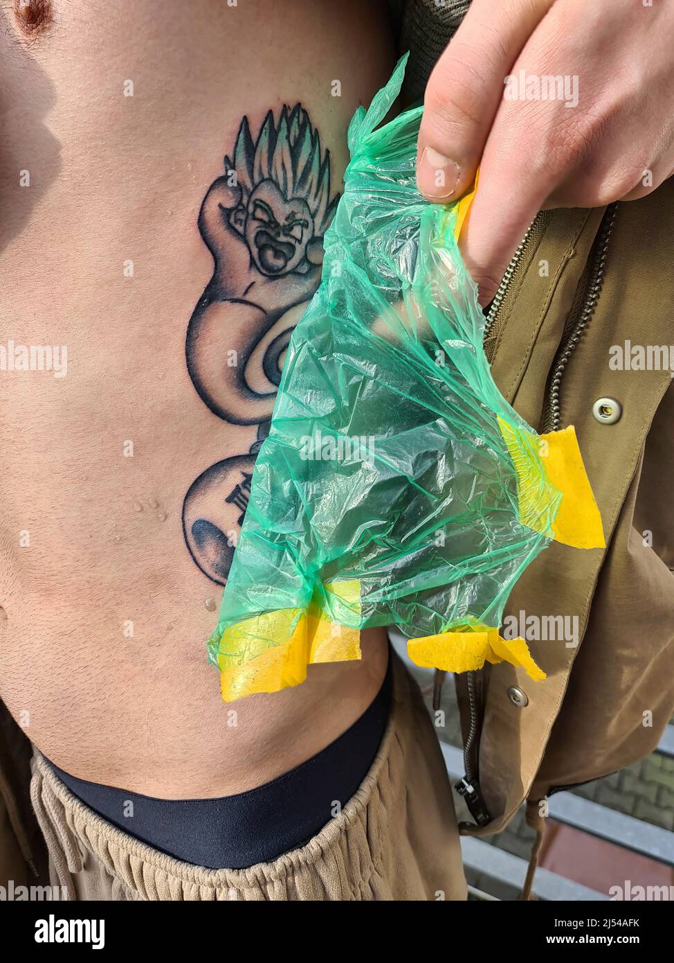 man removing protective foil from a freshly inked tattoo Stock Photo ...