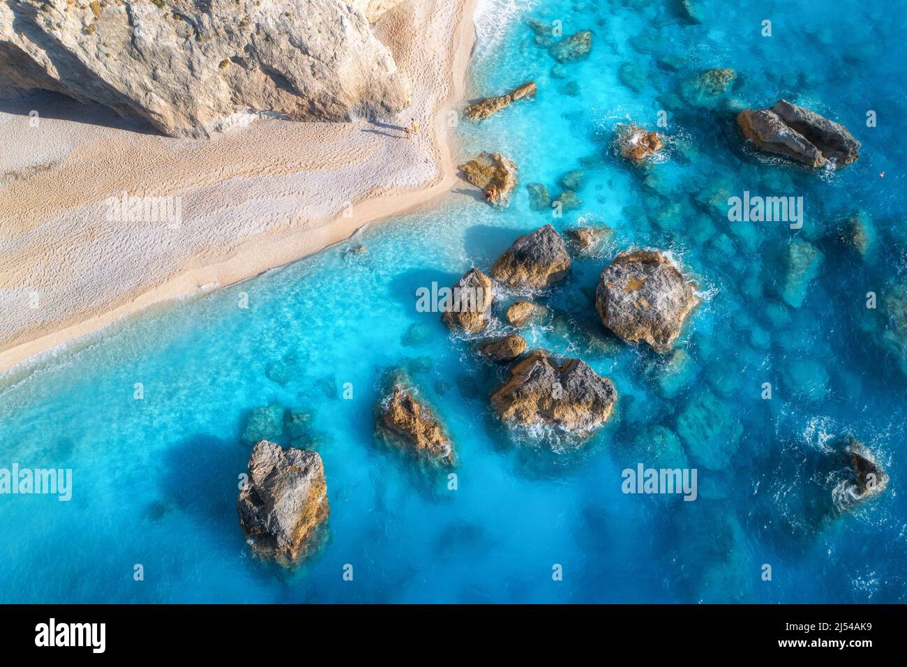 Aerial view of blue sea, rocks in clear water, white sandy beach Stock ...