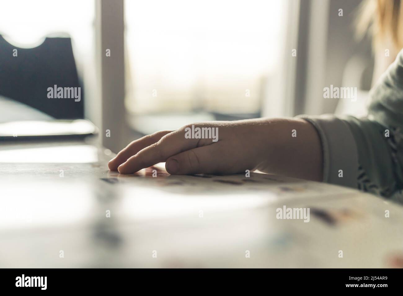 Child's hands on the table with a piece of paper. Top view. Child ...