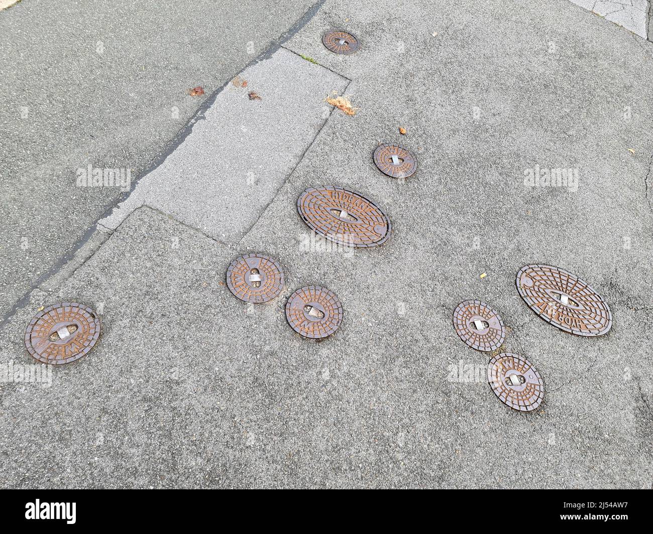 various street caps for hydrants and gate valves on the pavement ...