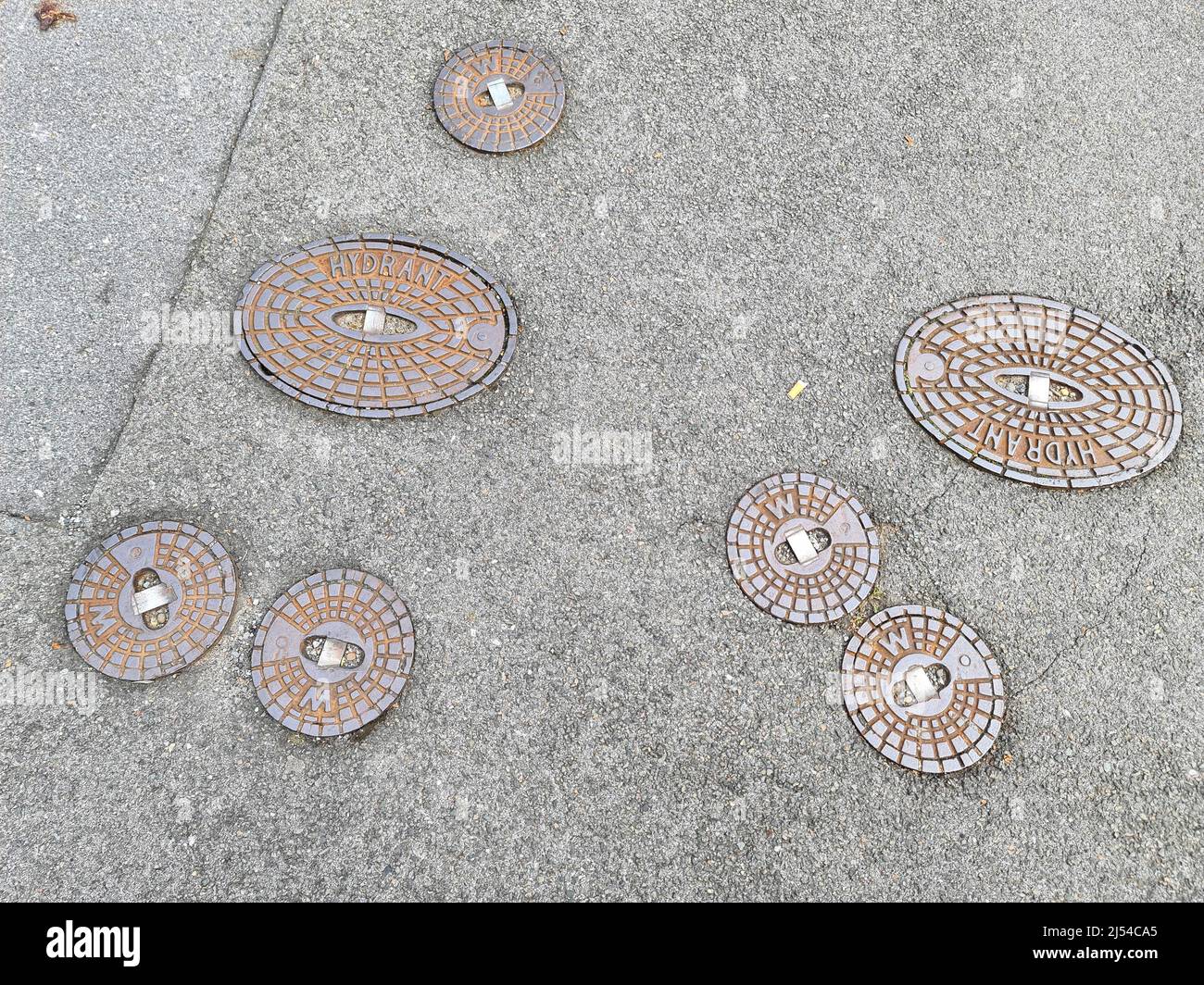 various street caps for hydrants and gate valves on the pavement ...