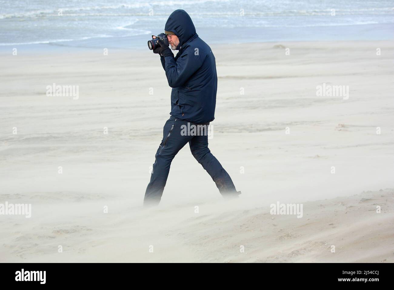 man in the storm on the sandy beach, Hurricane Eunice, Zeynep, 02/18 ...