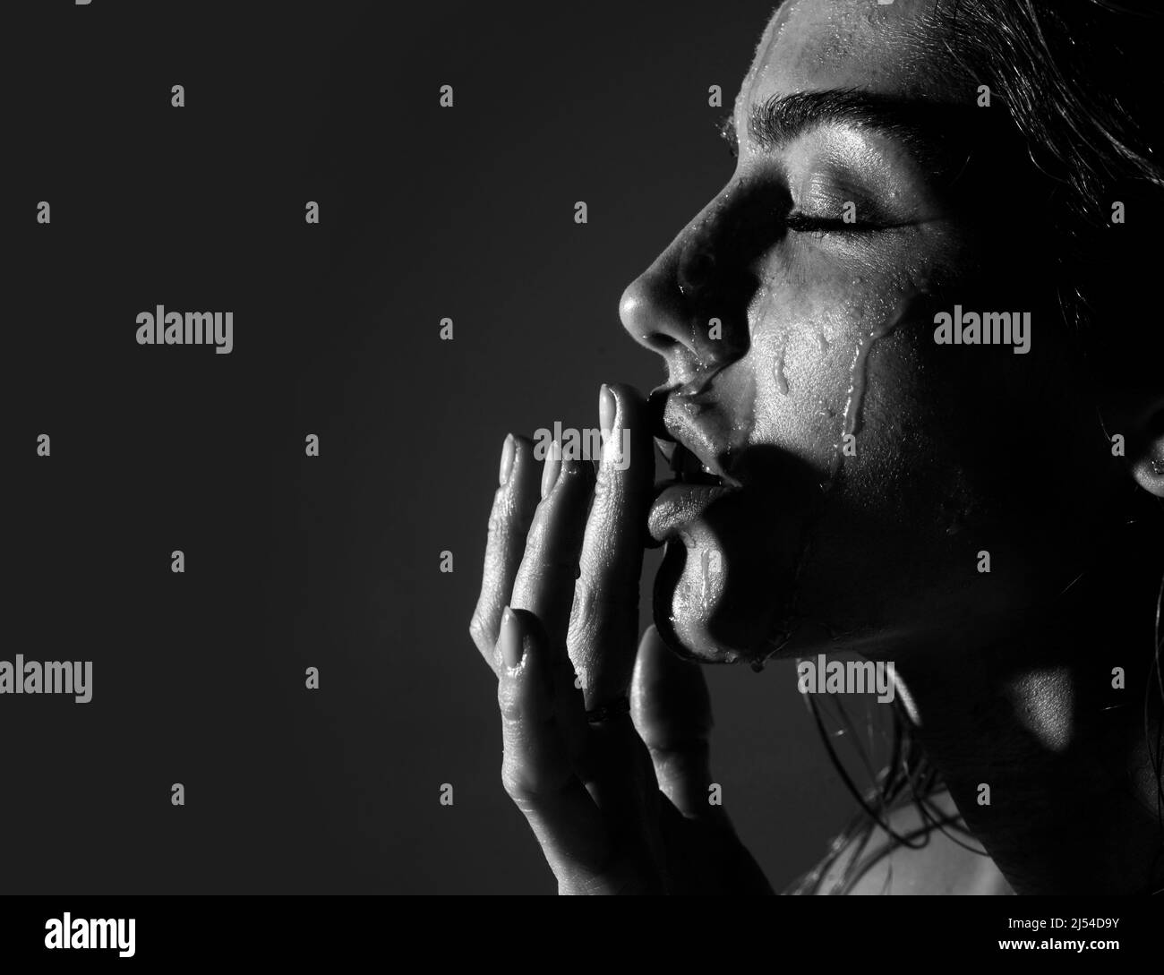 Beautiful woman with honey flows down on her face. Portrait of girl ...
