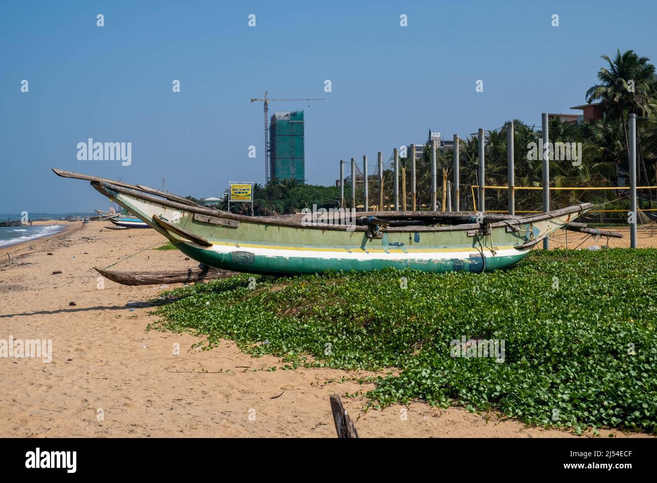 fishing catamaran on the background of a building under construction ...