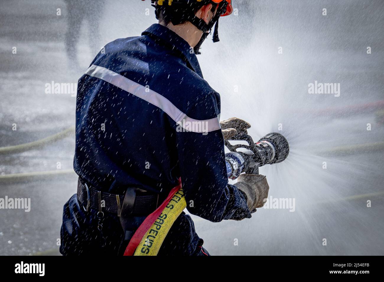person holding a fire hose during a drill Stock Photo - Alamy