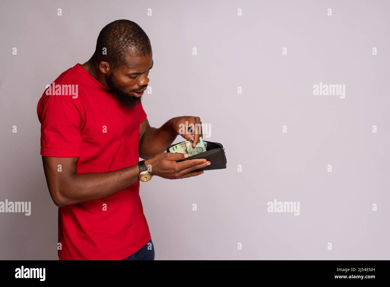 broke african man holding a wallet with little change Stock Photo - Alamy