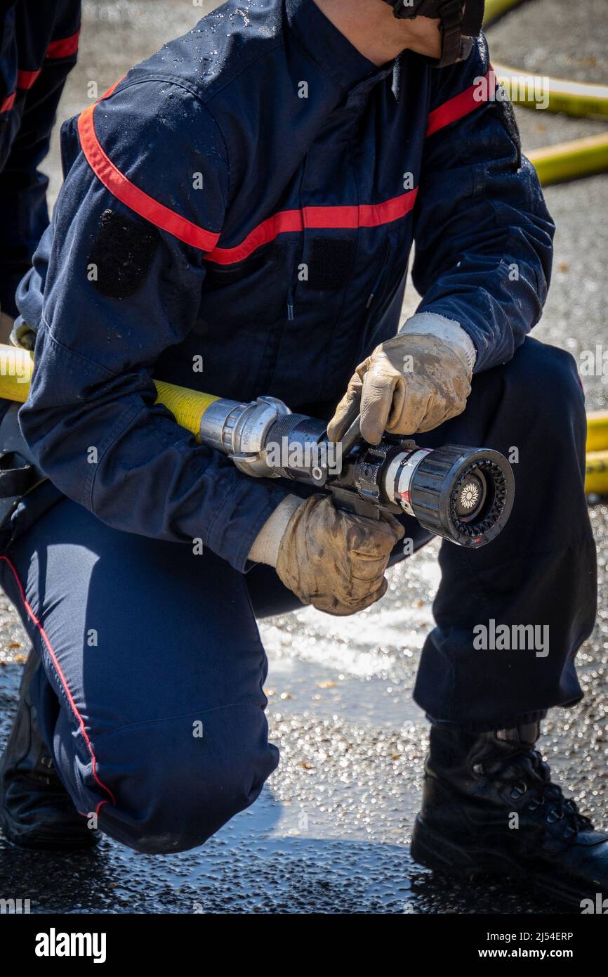 person holding a fire hose during a drill Stock Photo - Alamy