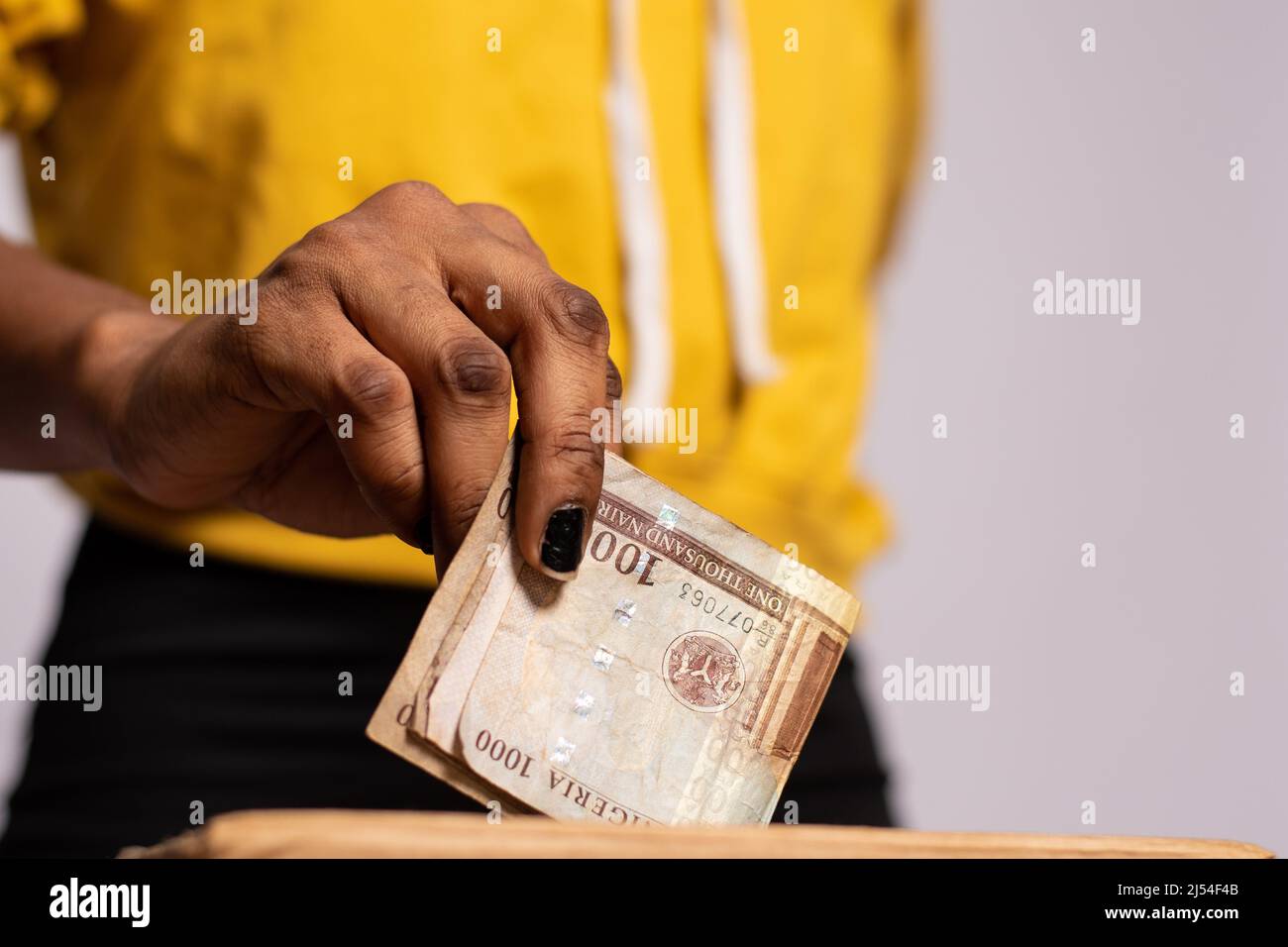 african lady saving money in a box Stock Photo - Alamy