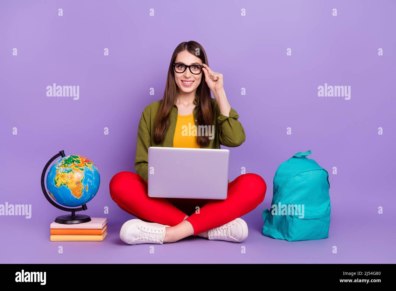 Portrait of attractive cheery skillled girl using laptop doing homework ...