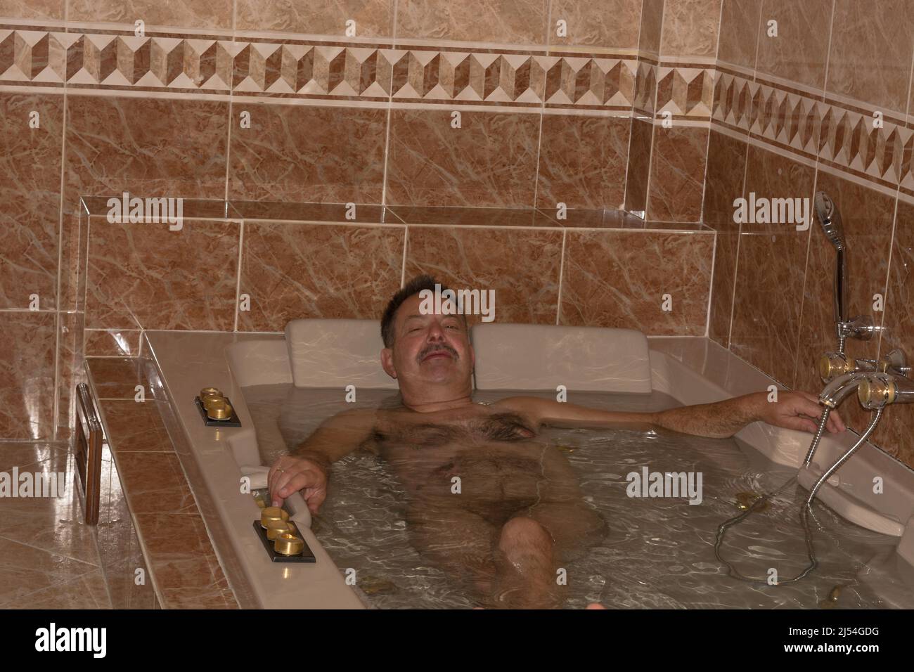Man in luxury bathroom with whirlpool, shower and sink Stock Photo - Alamy