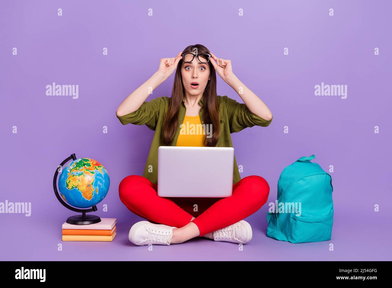 Portrait of attractive stunned girl using laptop doing homework science ...
