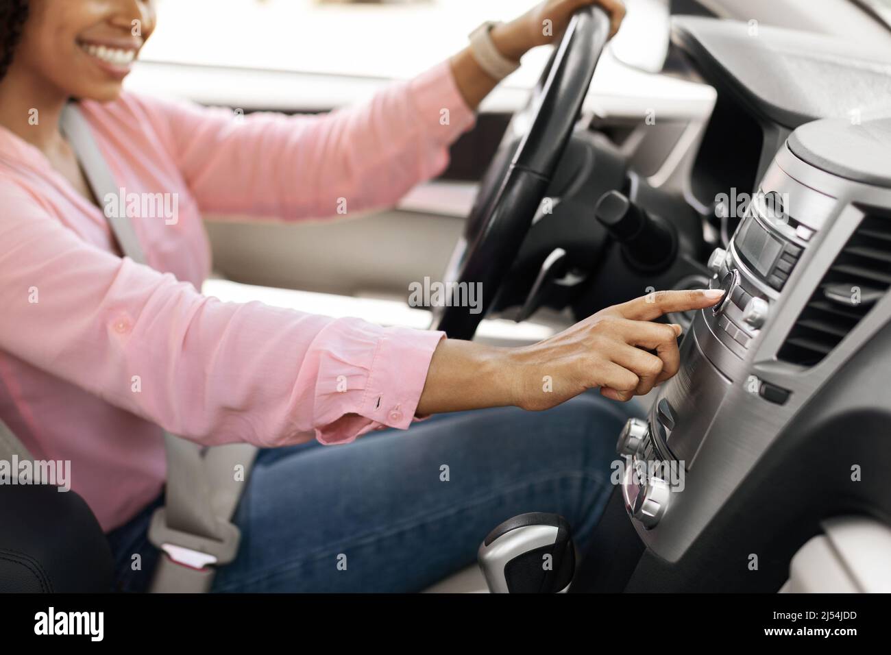 Smiling black woman driving new car in city Stock Photo - Alamy