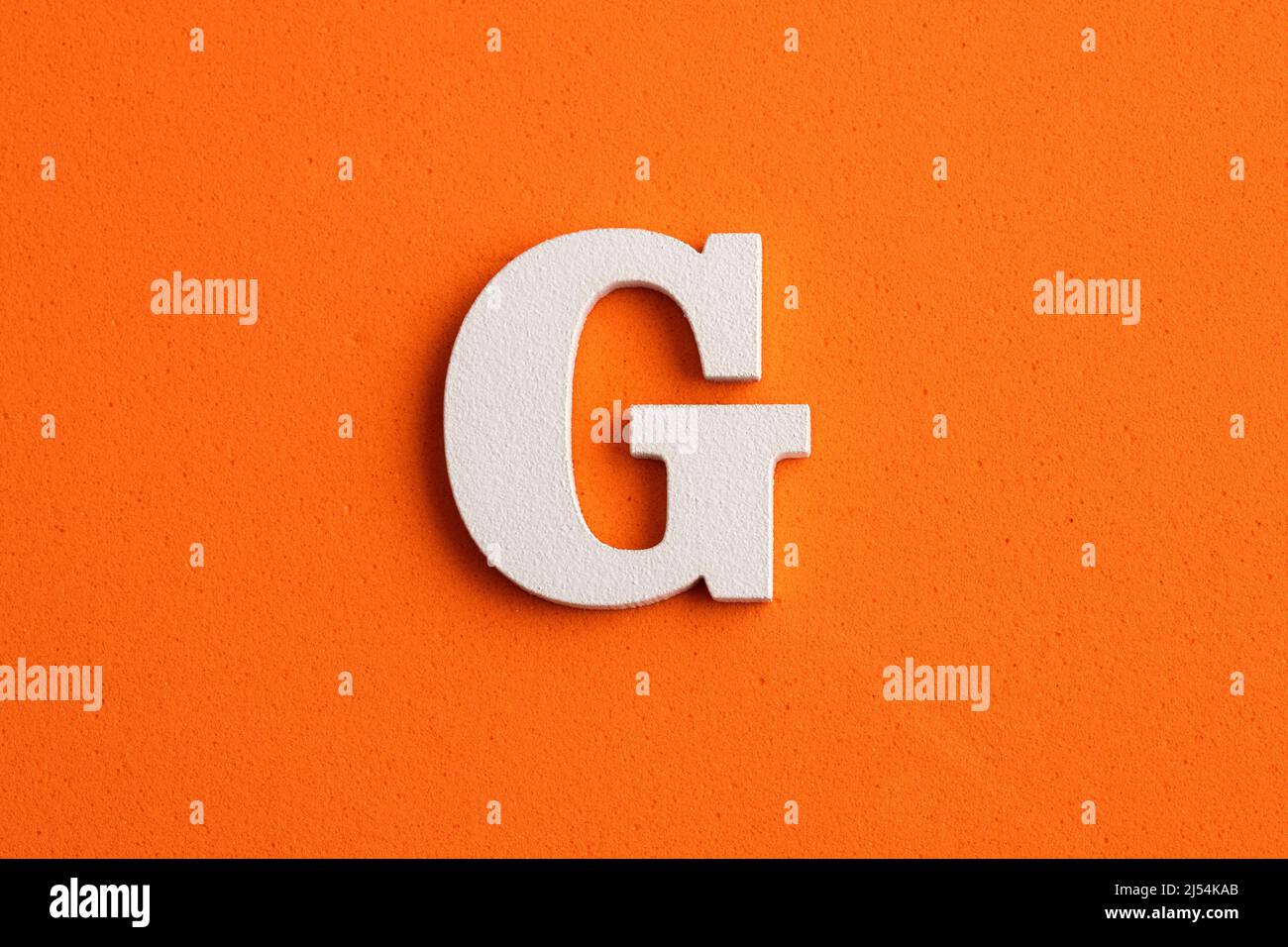 White wooden capital letter G on orange foamy background Stock Photo ...