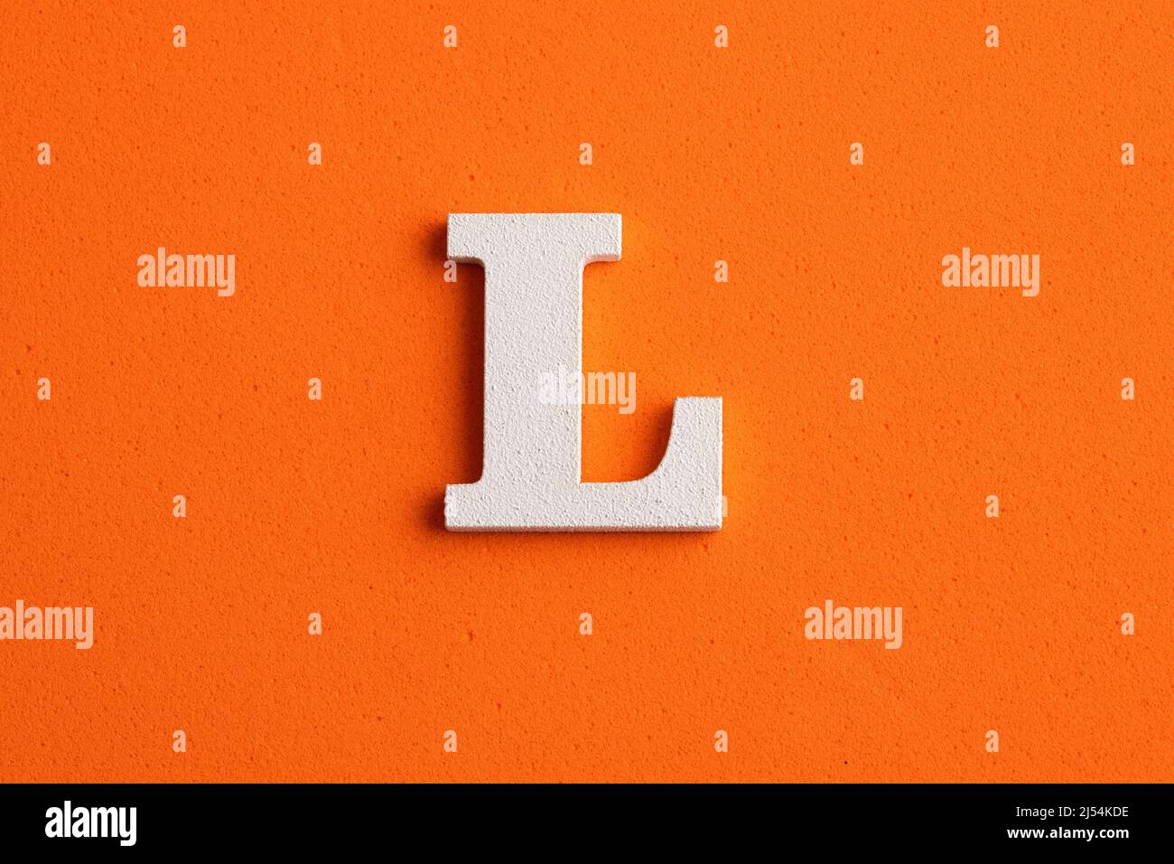 Alphabet letter L - White wood piece on orange foamy background Stock ...