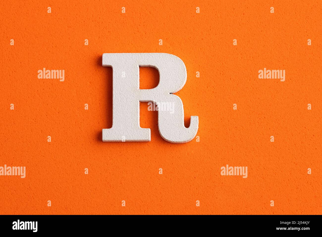 Alphabet letter R - White wood piece on orange foamy background Stock ...