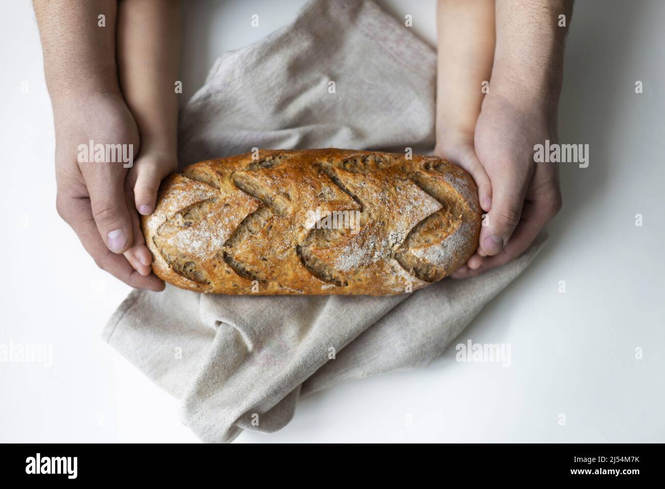 Top view of oblong bread in the hands of father and son Stock Photo - Alamy