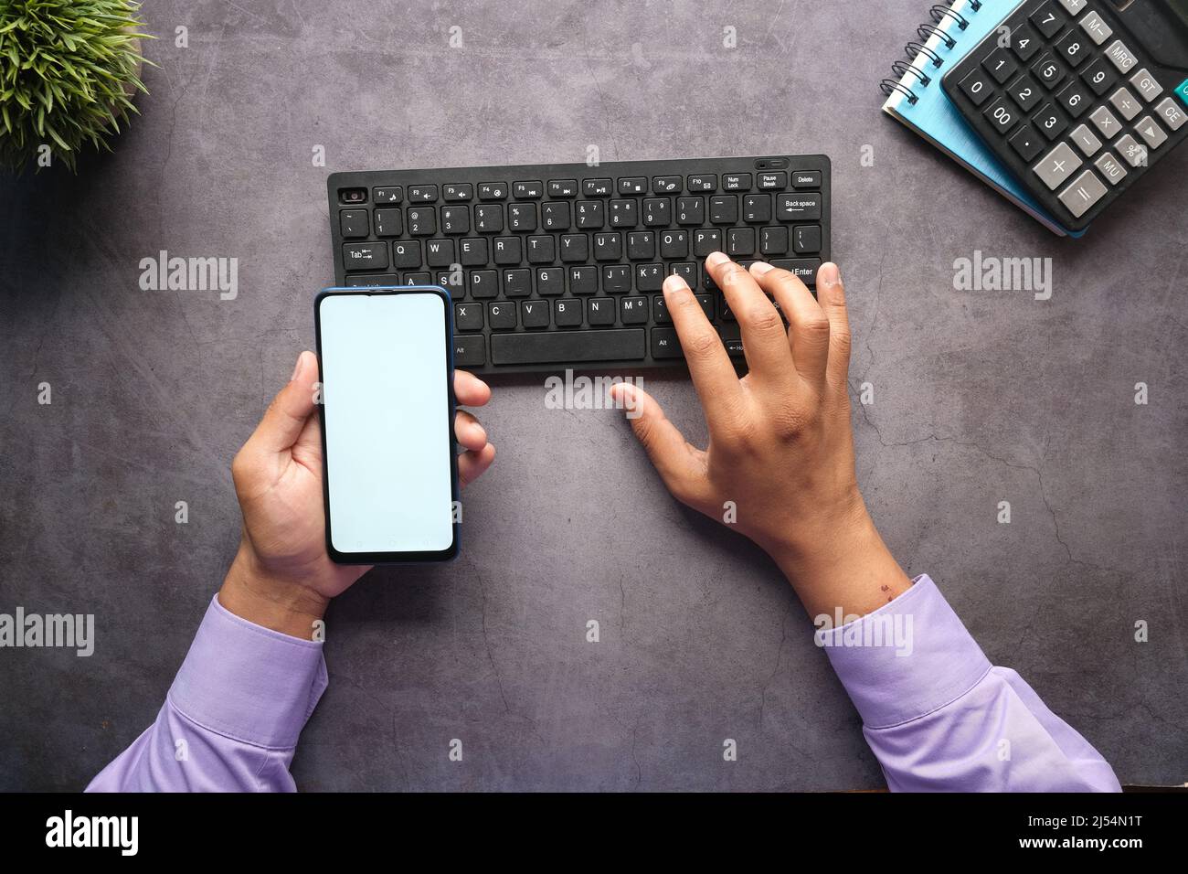 Top view of man hand holding smart phone with empty screen on office ...