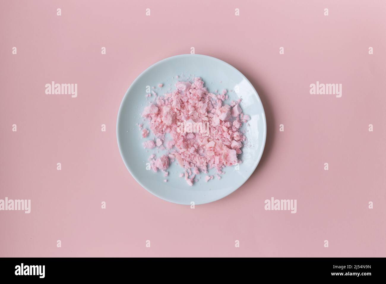 Top view of one smashed pink meringue on the light blue plate Stock ...