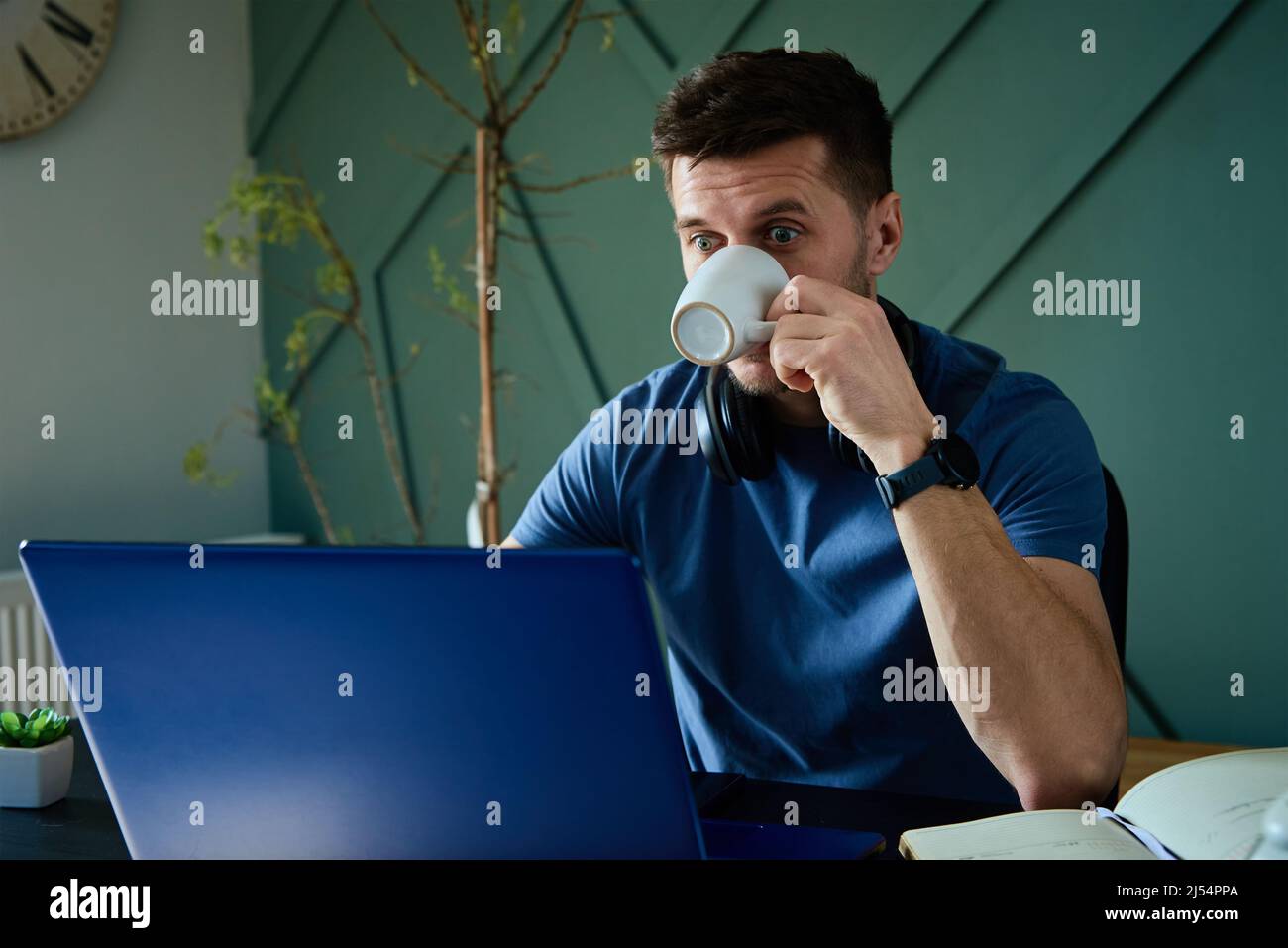 Surprised man looking at laptop screen Stock Photo - Alamy
