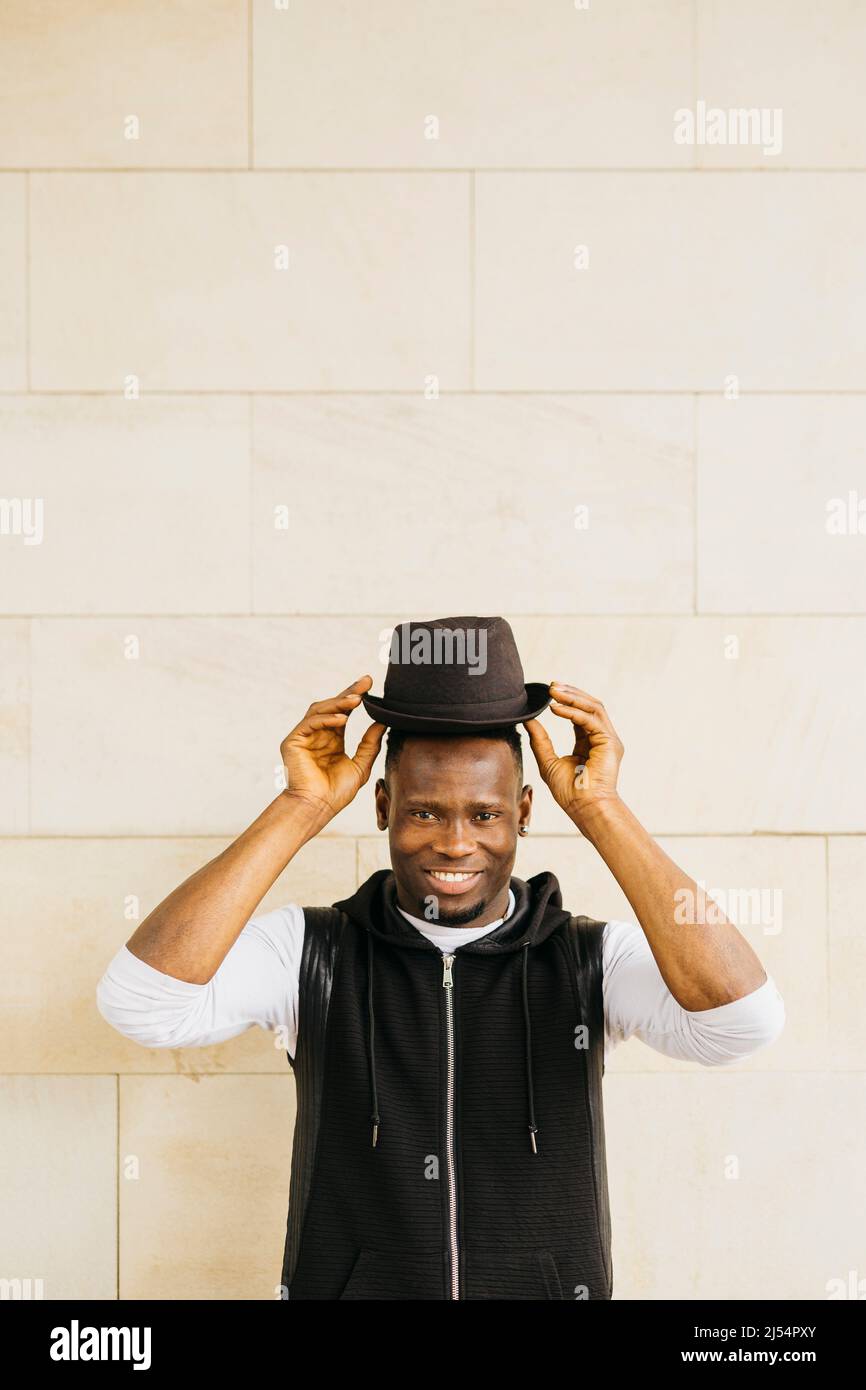 Portrait of a young black male taking off his black hat Stock Photo - Alamy