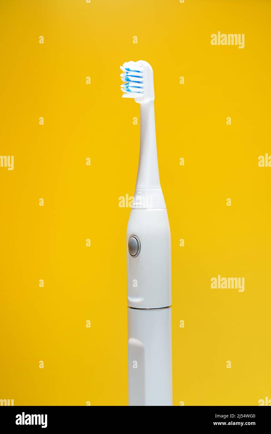 Electric ultrasonic toothbrush on yellow background Stock Photo - Alamy