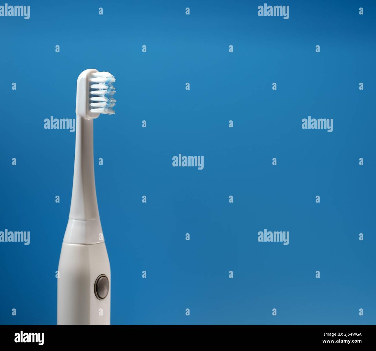 Electric ultrasonic toothbrush on blue background Stock Photo - Alamy
