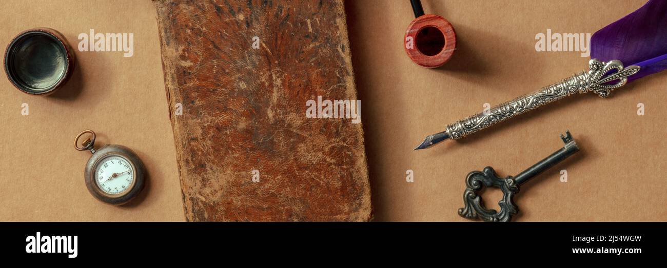 Mysterious vintage objects panorama. Old notebook, a retro key, a quill ...