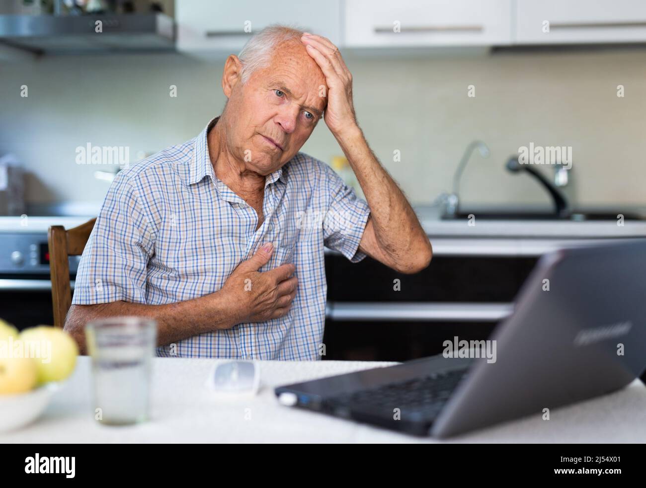 A modern elderly man is sitting at home, conducting an online ...