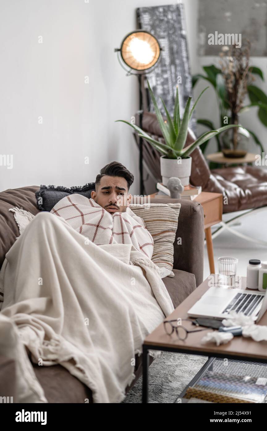 A sick man feeling bad and lying in bed Stock Photo - Alamy